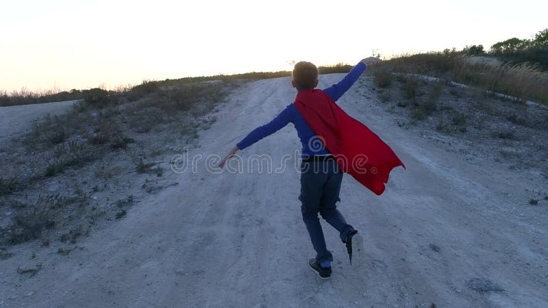 A Boy Dressed Up with a Cape of Superman Standing on a Mountain Looking ...