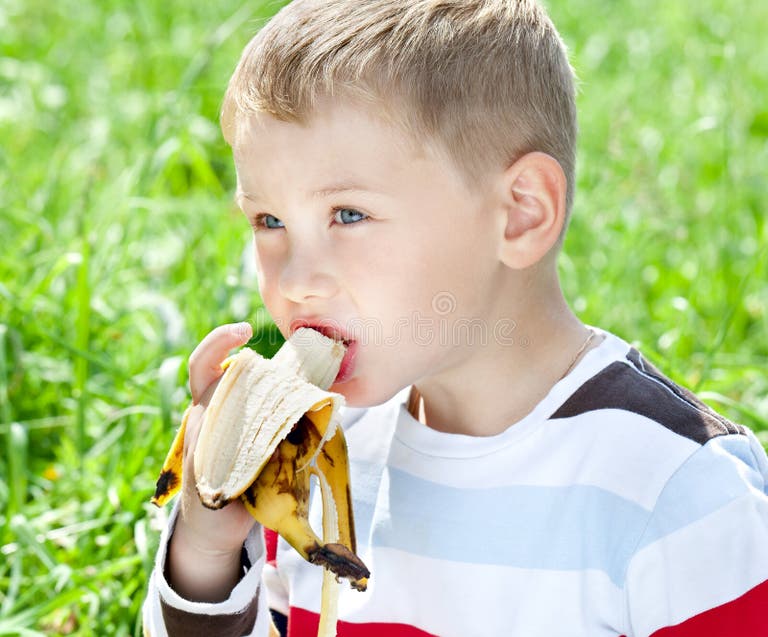 Boy eating banana stock photo. Image of emotion, grass - 25168594