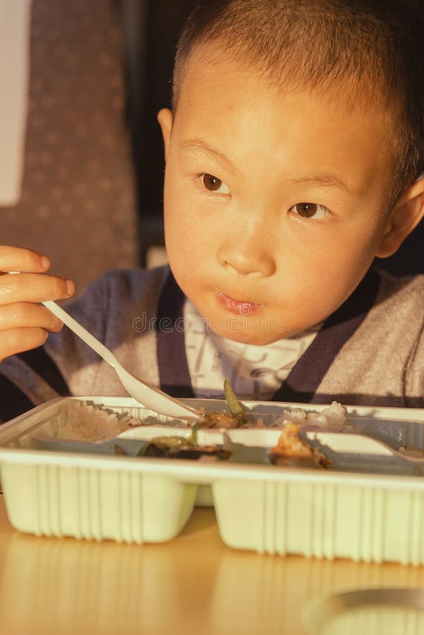 Boy eating box lunch stock photo. Image of eating, vertical - 54589548