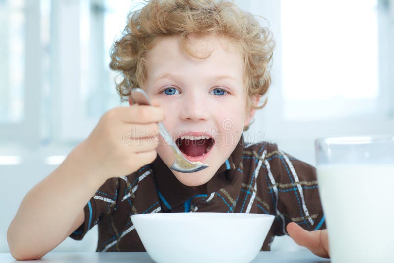 Boy Eating Cereal while Having Breakfast in the Kitchen. Stock Photo ...