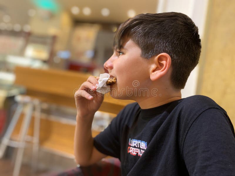 Boy Eating a Chocolate Cookie with a Napkin To Avoid Staining Stock ...