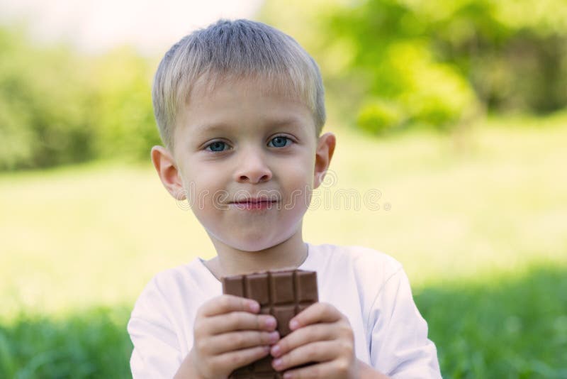 Boy Eating Chocolate with Pleasure Stock Photo - Image of young, park ...