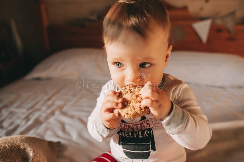 Boy eating cookies in bed stock photo. Image of home - 82608414