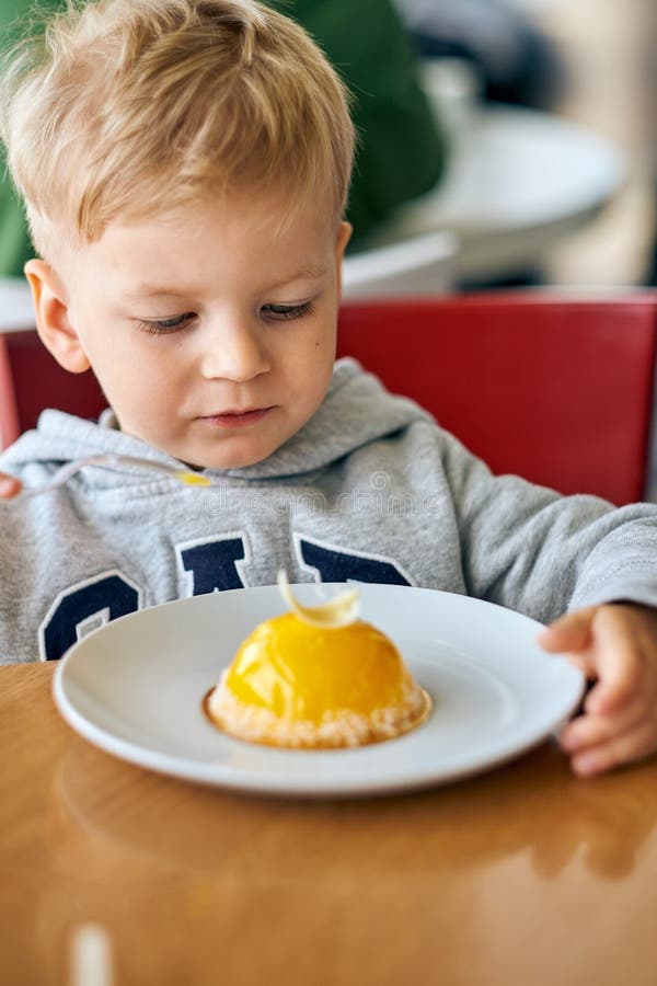 Boy eating dessert in cafe stock photo. Image of blond - 156902554