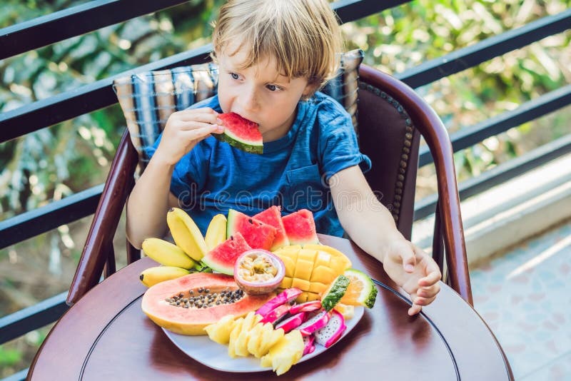 The Boy is Eating Different Fruits on the Terrace Stock Photo - Image ...