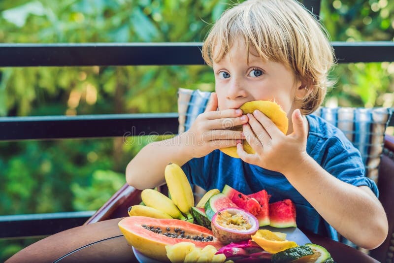 The Boy is Eating Different Fruits on the Terrace Stock Image - Image ...