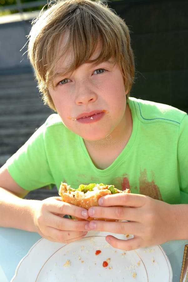 Boy is eating hamburger stock photo. Image of portrait - 42615322