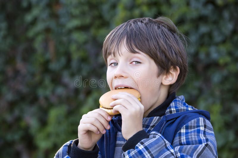 Boy eating a hamburger stock image. Image of green, kids - 45266599