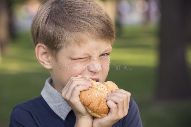 Boy eating a hamburger stock photo. Image of kids, green - 45560244