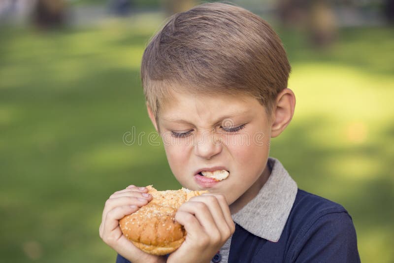Boy eating a hamburger stock photo. Image of kids, green - 45560244