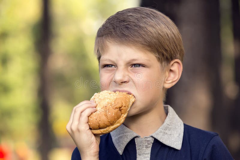 Boy eating a hamburger stock photo. Image of eating, male - 46879398