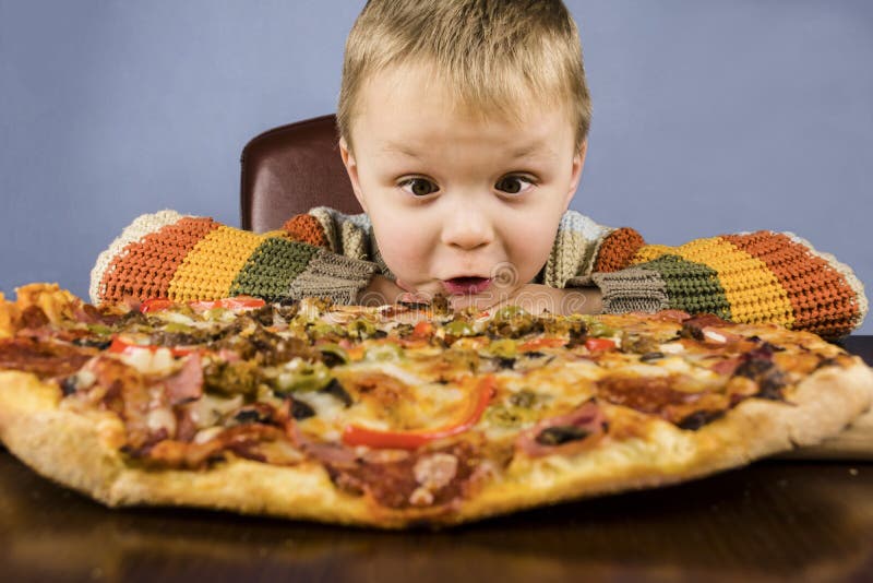 Boy eating pizza stock image. Image of knife, pizza, table - 65820237