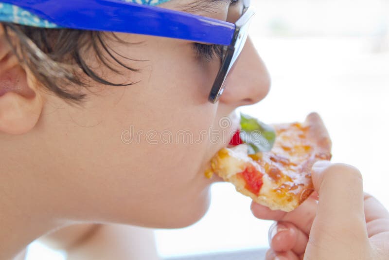 The boy is eating pizza stock image. Image of unhealthy - 59757497