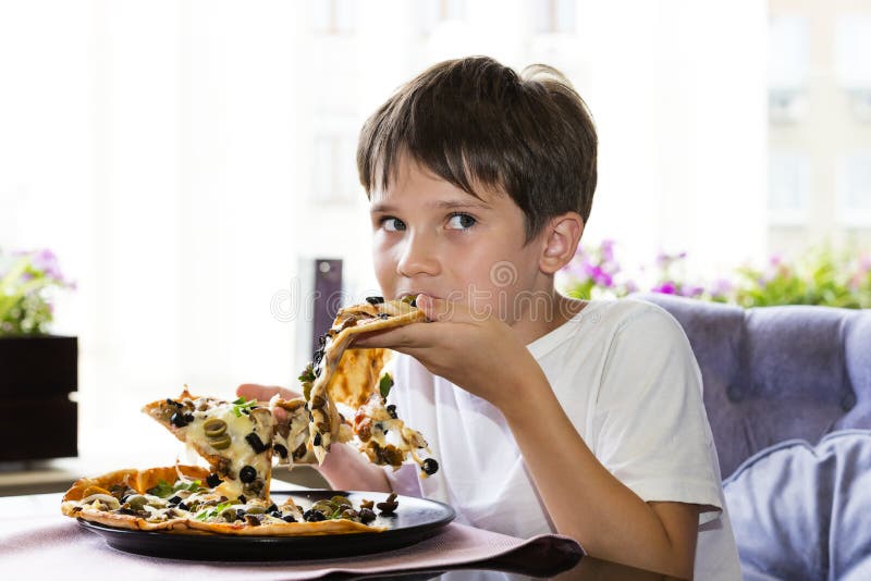 The boy is eating pizza stock image. Image of restaurant - 97603891