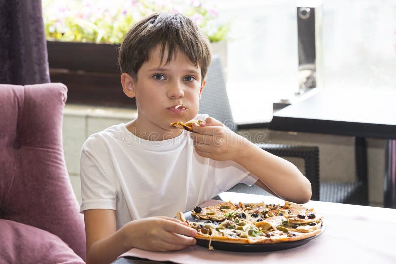 The boy is eating pizza stock image. Image of piece, child - 99950365