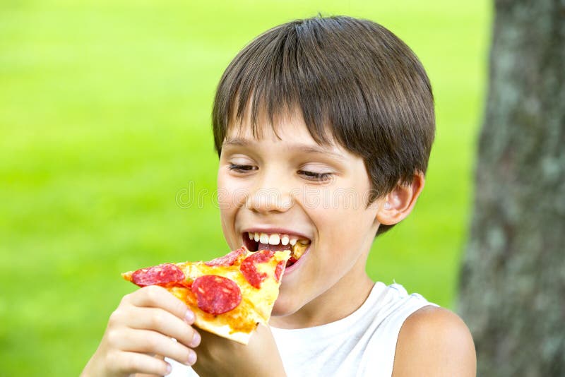 The boy is eating pizza stock photo. Image of portion - 97603864