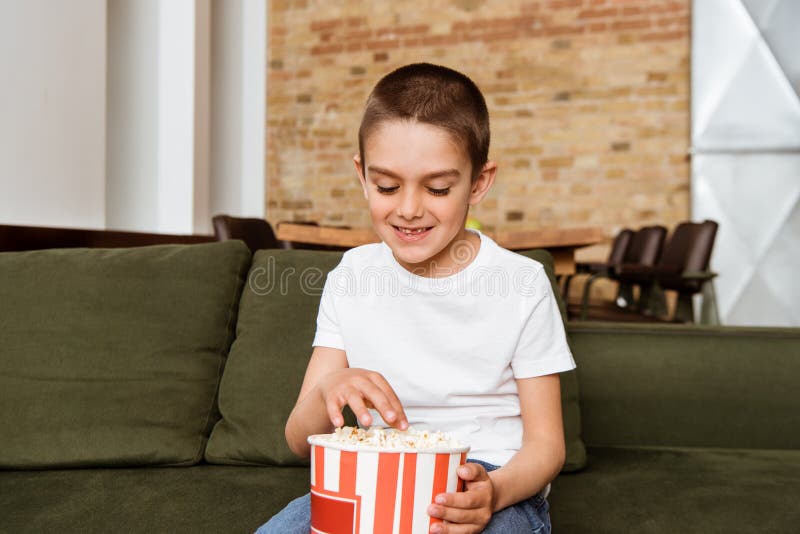Boy Eating Popcorn while Sitting on Stock Photo - Image of emotional ...