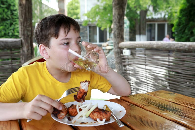 Boy eating pork neck kebab stock photo. Image of meal - 255554558