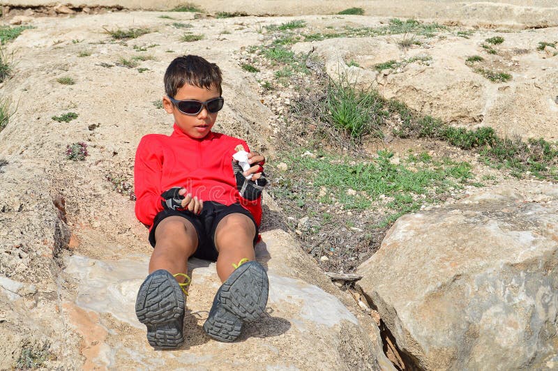 A Boy Eating on the Rocks stock image. Image of dark - 61118303