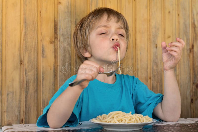 The Boy is Eating Spaghetti. he Narrowed His Eyes with Pleasure ...