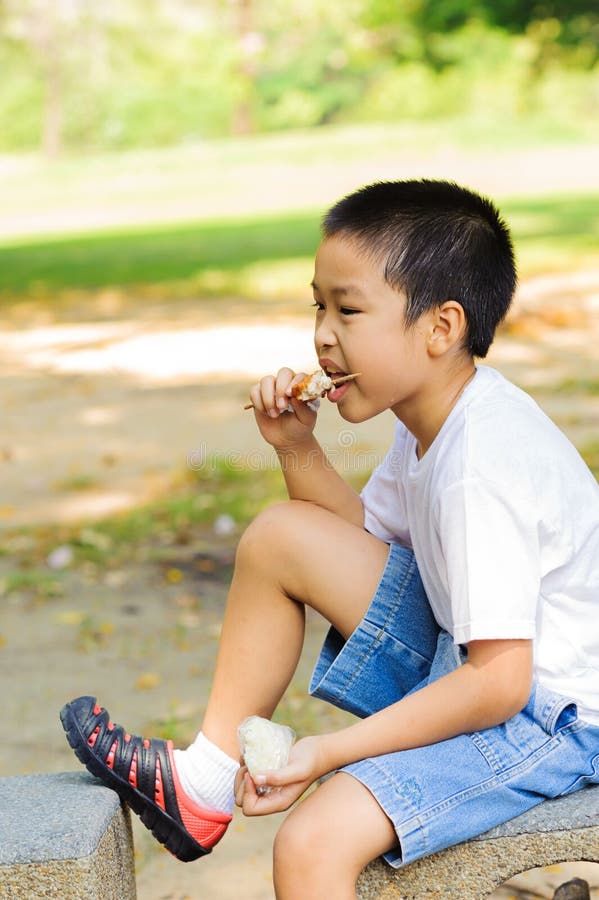 Boy eating stick chicken stock photo. Image of child - 61179674