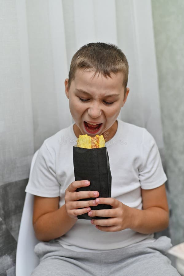 The Boy Eats Delicious Shawarma with an Appetite. Stock Image - Image ...