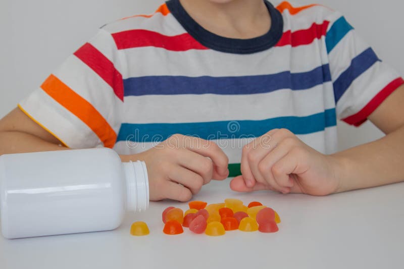 The Boy Eats Jelly Beans or Takes Vitamins Stock Image - Image of color ...