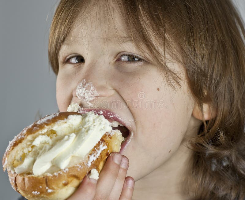 Young Boy Enjoying a Cream Bun with Almond Paste Stock Image - Image of ...