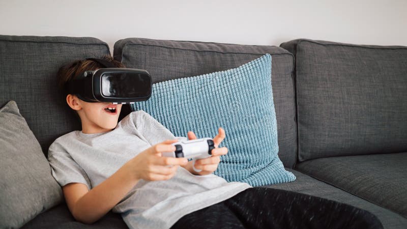 Boy Enjoying at Home, Gaming Using VR Goggles and a Simulator Stock ...