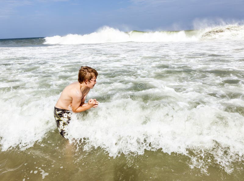 Boy Enjoys the Waves in the Rough Ocean Stock Image - Image of brown ...