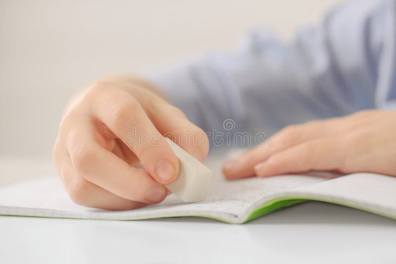 Boy Erasing Mistake in His Notebook at White Desk, Closeup Stock Image ...