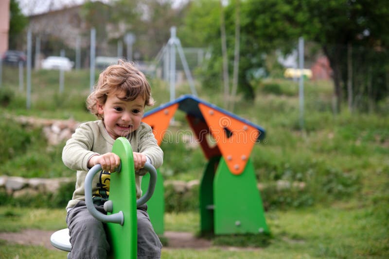 Boy with an Excited Face Playing in the Park with a Spring Rocker Stock ...