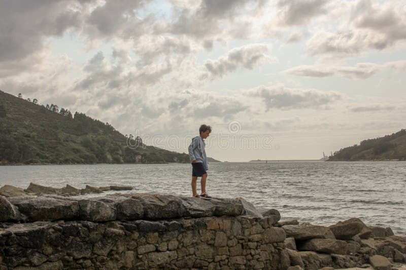 A boy exploring a beach stock image. Image of male, eroded - 316237733