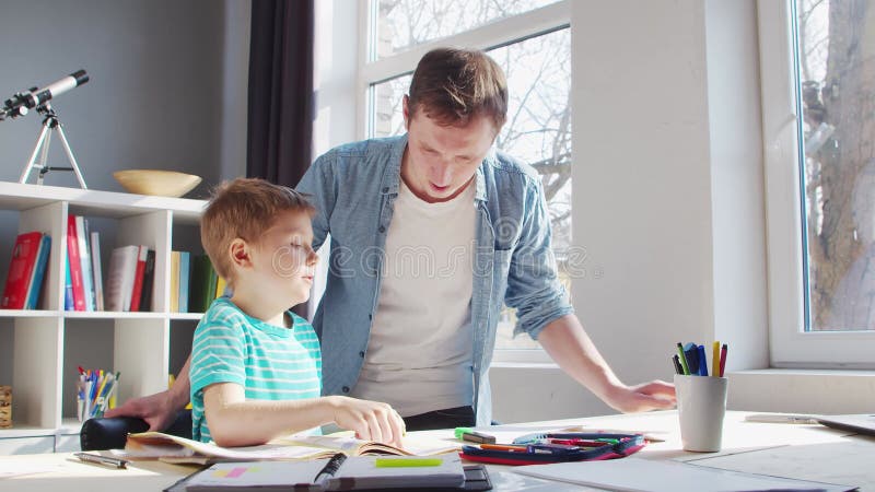 Boy and Father are Doing Homework at the Table. Cute Child is Learning ...