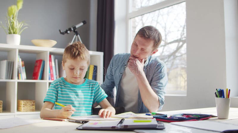 Boy and Father are Doing Homework at the Table. Cute Child is Learning ...