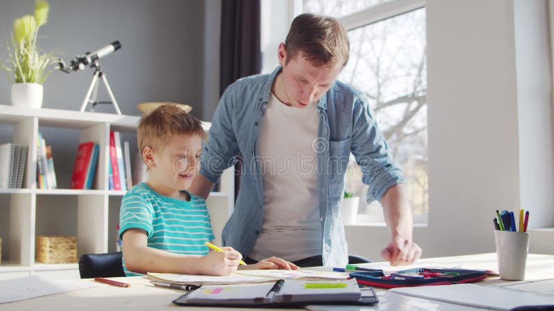 Boy and Father are Doing Homework at the Table. Cute Child is Learning ...