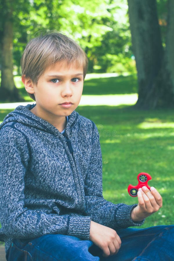 Boy with a Fidget Spinner Outdoors Stock Photo - Image of finger ...