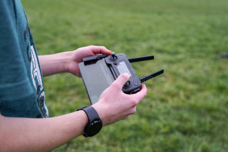 A Boy in a Field Launches a Quadcopter and Controls it from the Remote ...