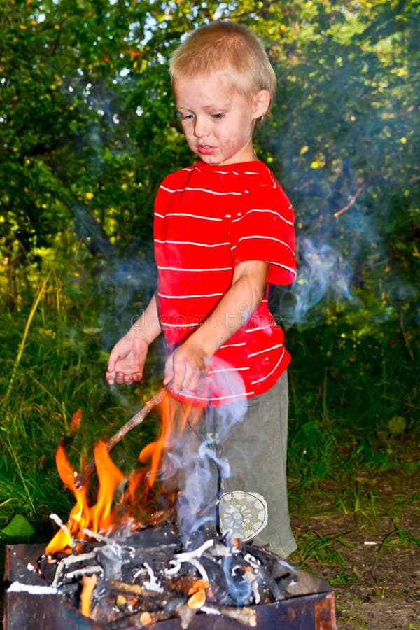 A boy and a fire stock photo. Image of holiday, grass - 33031568