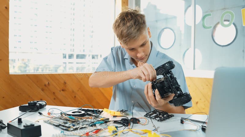 Boy Fixing Car Model with Laptop and Electric Tool Placed on Table ...