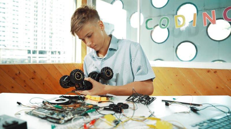 Boy Fixing Car Model with Laptop and Electric Tool Placed on Table ...