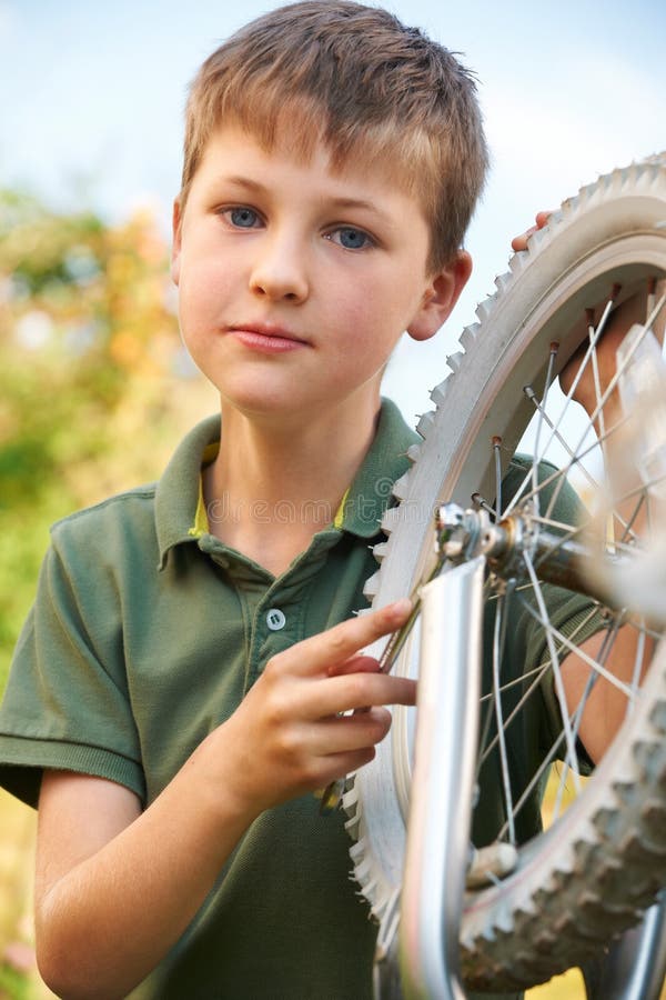 Boy Fixing Wheel of Bike stock photo. Image of smiling - 63543518