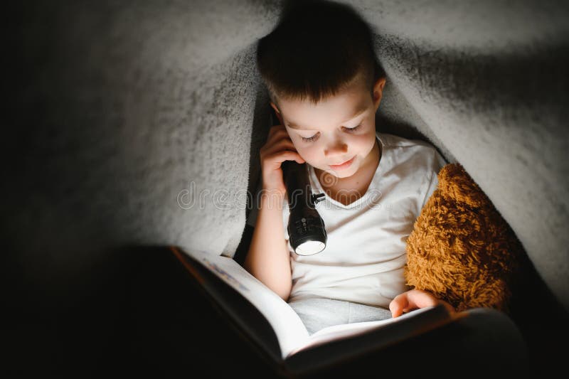 Boy with Flashlight Reading Book Under Blanket at Home. Stock Image ... Boy with Flashlight Reading Book Under Blanket at Home. Stock Image ...