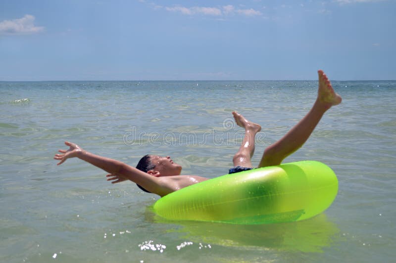 Boy floating in green ring stock image. Image of summer - 74837869