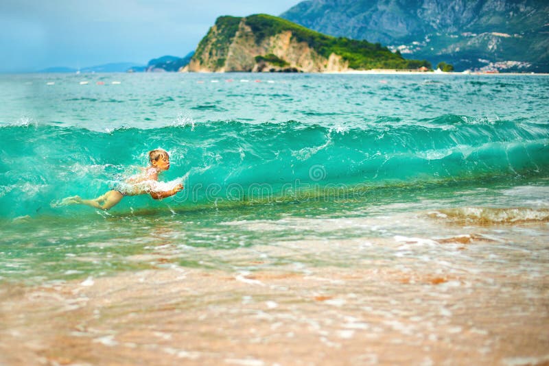 Boy floating on the waves stock photo. Image of play - 49252318