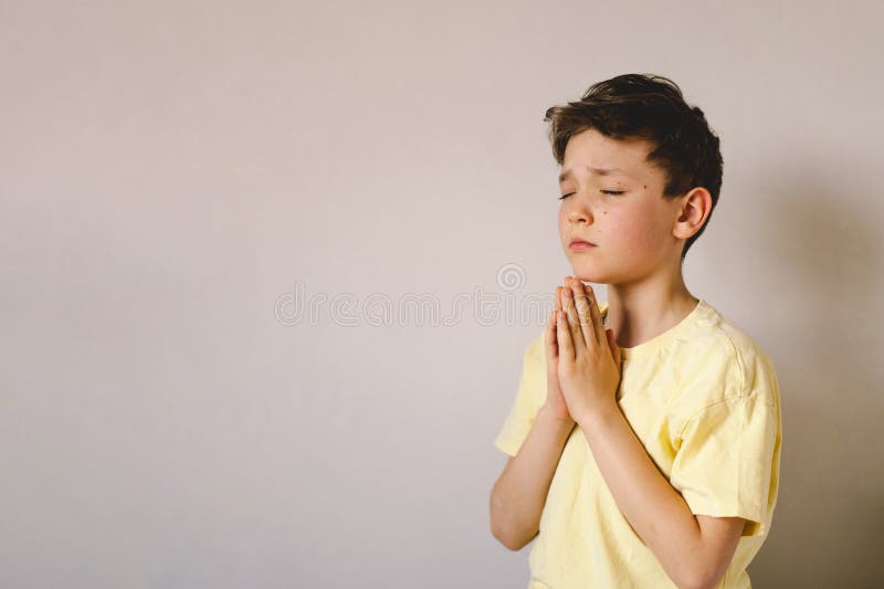 A Boy with Folded Hands in Front of Him, he Prays in His Room. Stock ...