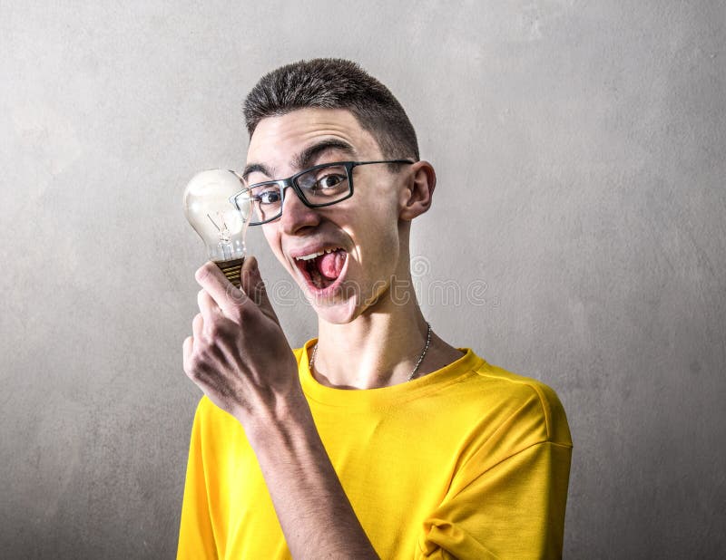 Boy with a Funny Look with a Light Bulb in Hand Stock Image - Image of ...