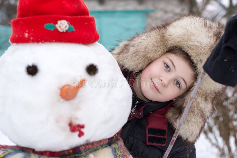 The Boy in a Fur Hat Around Snowman Stock Photo - Image of child ...