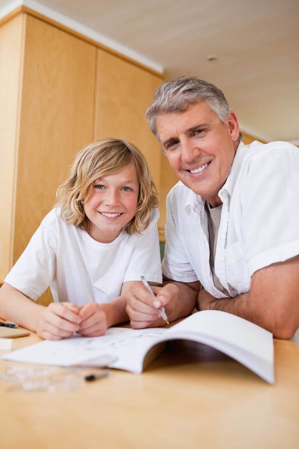 Man Helping Young Boy in Kitchen Doing Homework an Stock Photo - Image ...