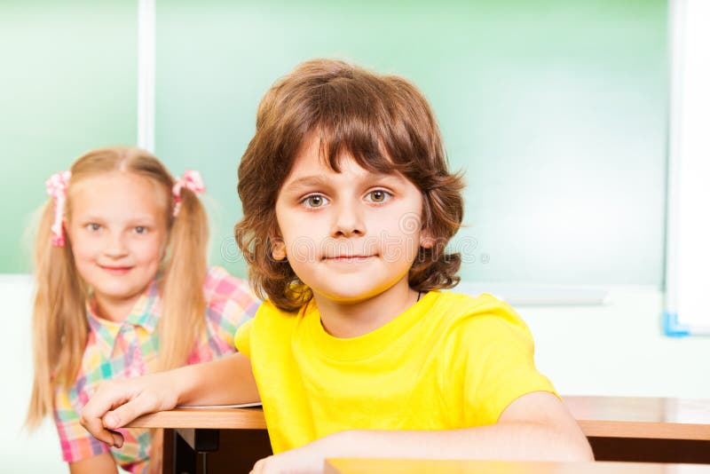 Boy and Girl Looking Straight Sitting at Desks Stock Image - Image of ...